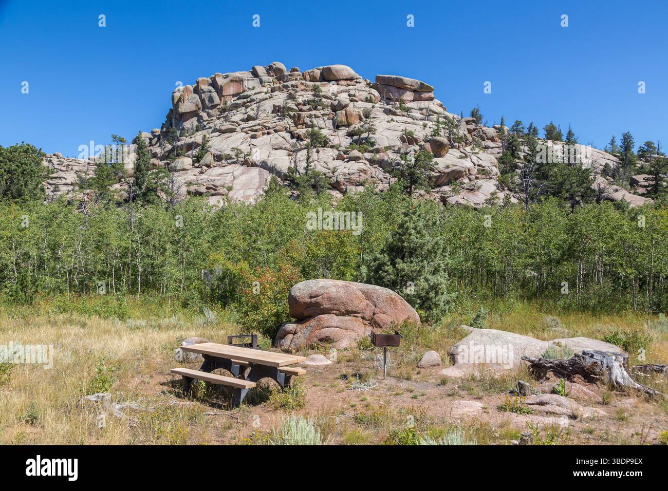 Granite rock outcropping behind a camp site with a picnic table, fire ...
