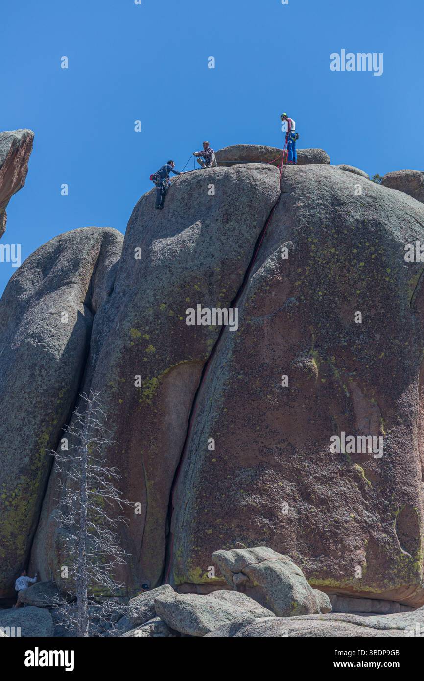 Men rock climbing on a large granite boulder in the Vedauwoo Recreation ...