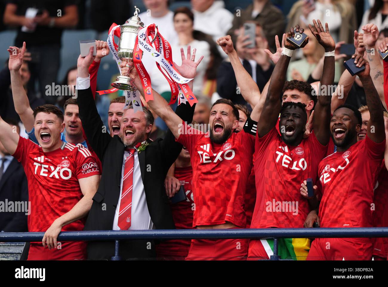 Aberdeen's Graeme Shinnie lifts the trophy with manager Jimmy Thelin ...