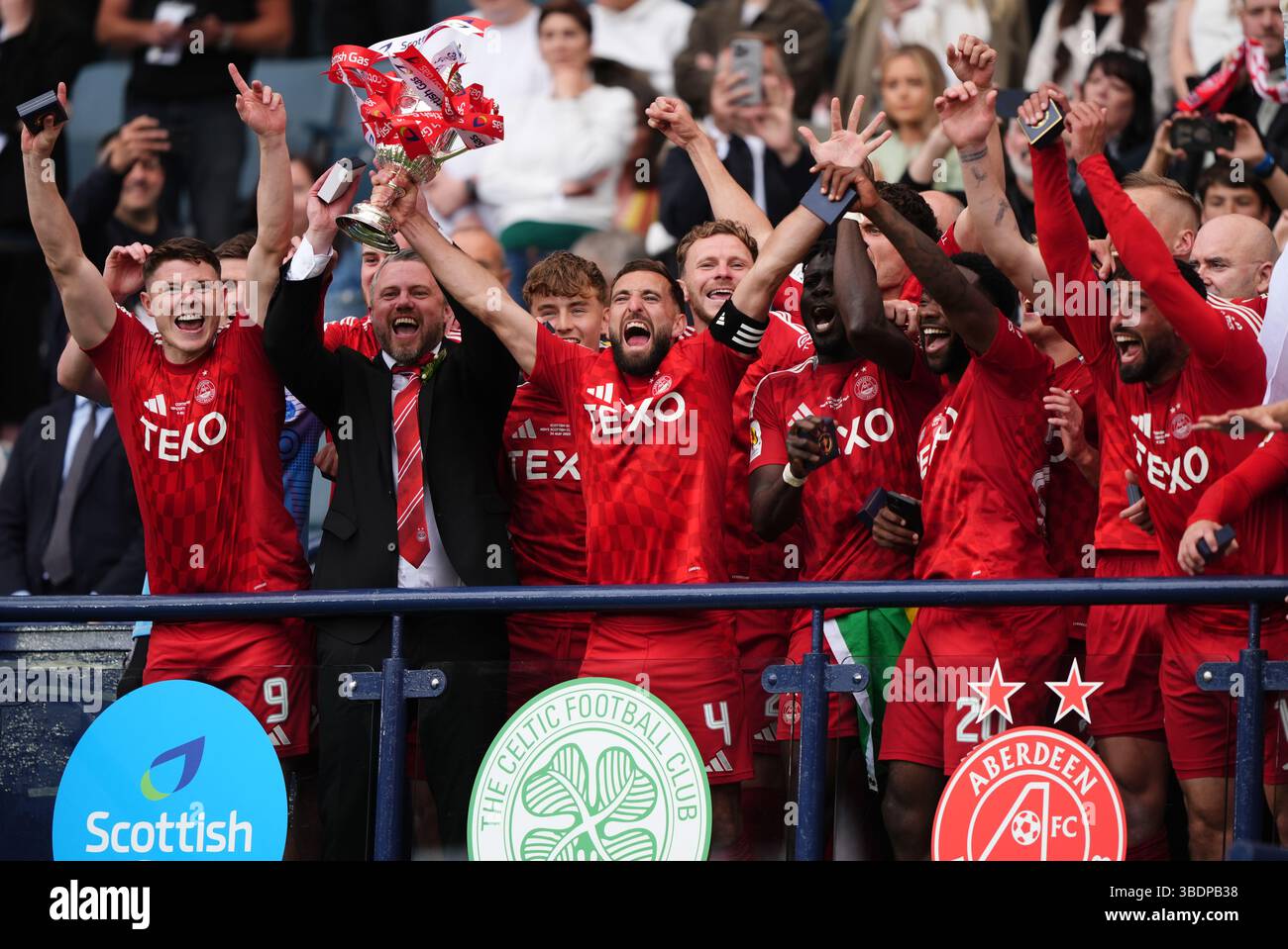 Aberdeen's Graeme Shinnie lifts the trophy with manager Jimmy Thelin ...