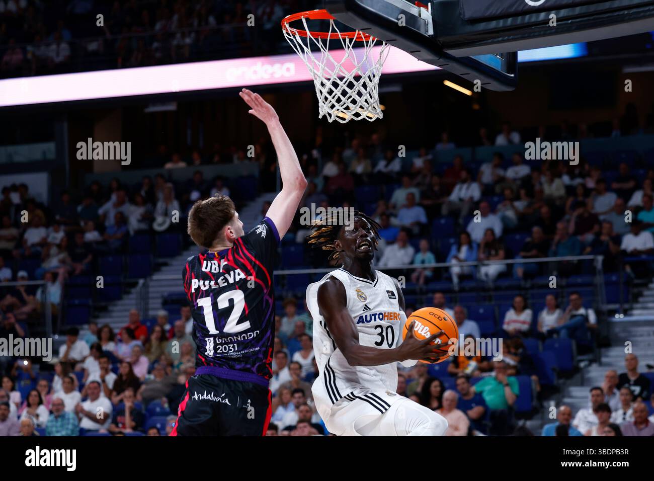 Eli John Ndiaye of Real Madrid and Agustin Ubal of Coviran Granada in action during the Spanish ...