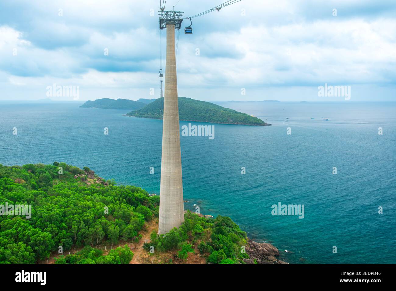 Cable car support tower rising above tropical green island forest and ...