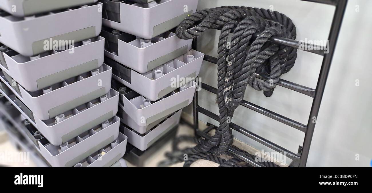 Step aerobic platforms and rope hanging on wall bars creating a fitness ...