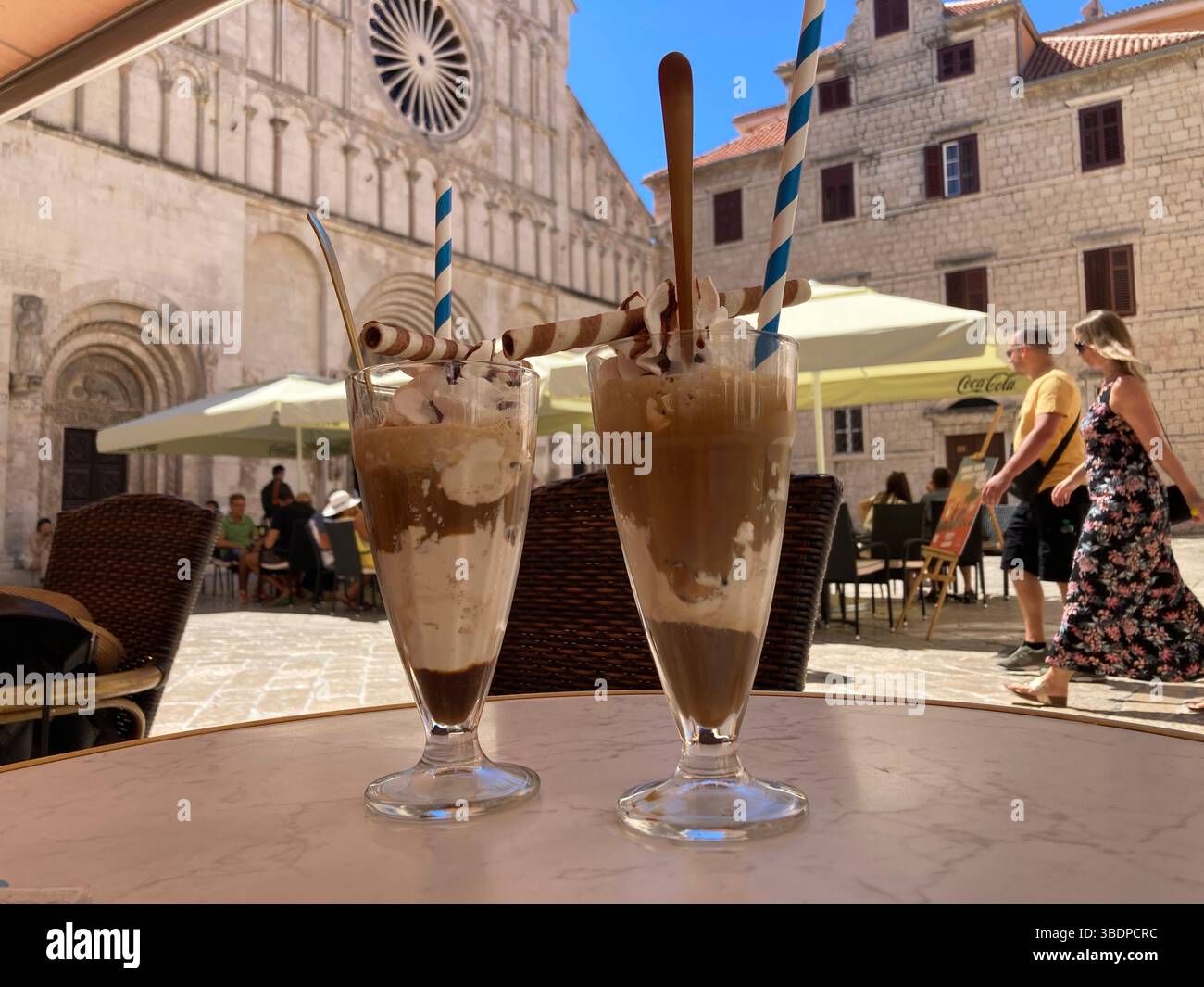 Two ice cream sundaes on a café table in a historic Zadar square, with ...