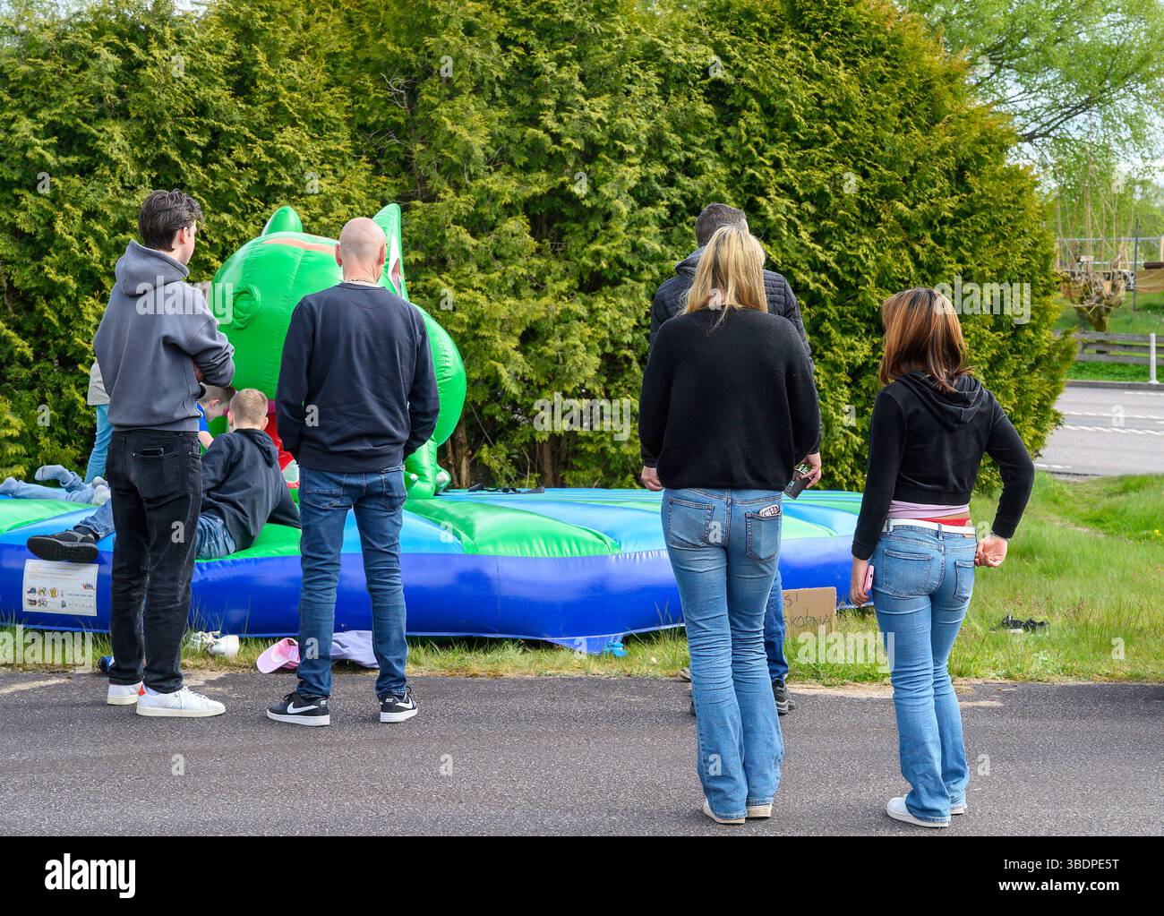 A group of people enjoys an outdoor gathering near an inflatable ...