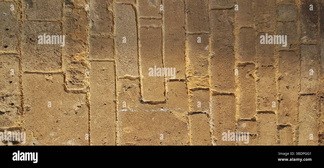 Textured background of an old sandstone brick wall, displaying ...