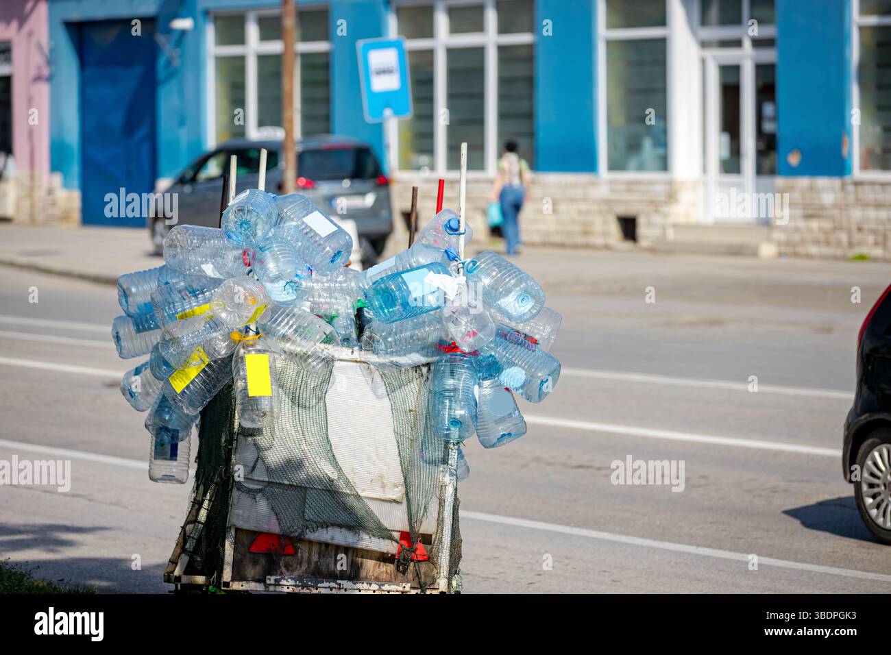 Loaded trailer attached to the motorcycle, bicycle with many empty used ...