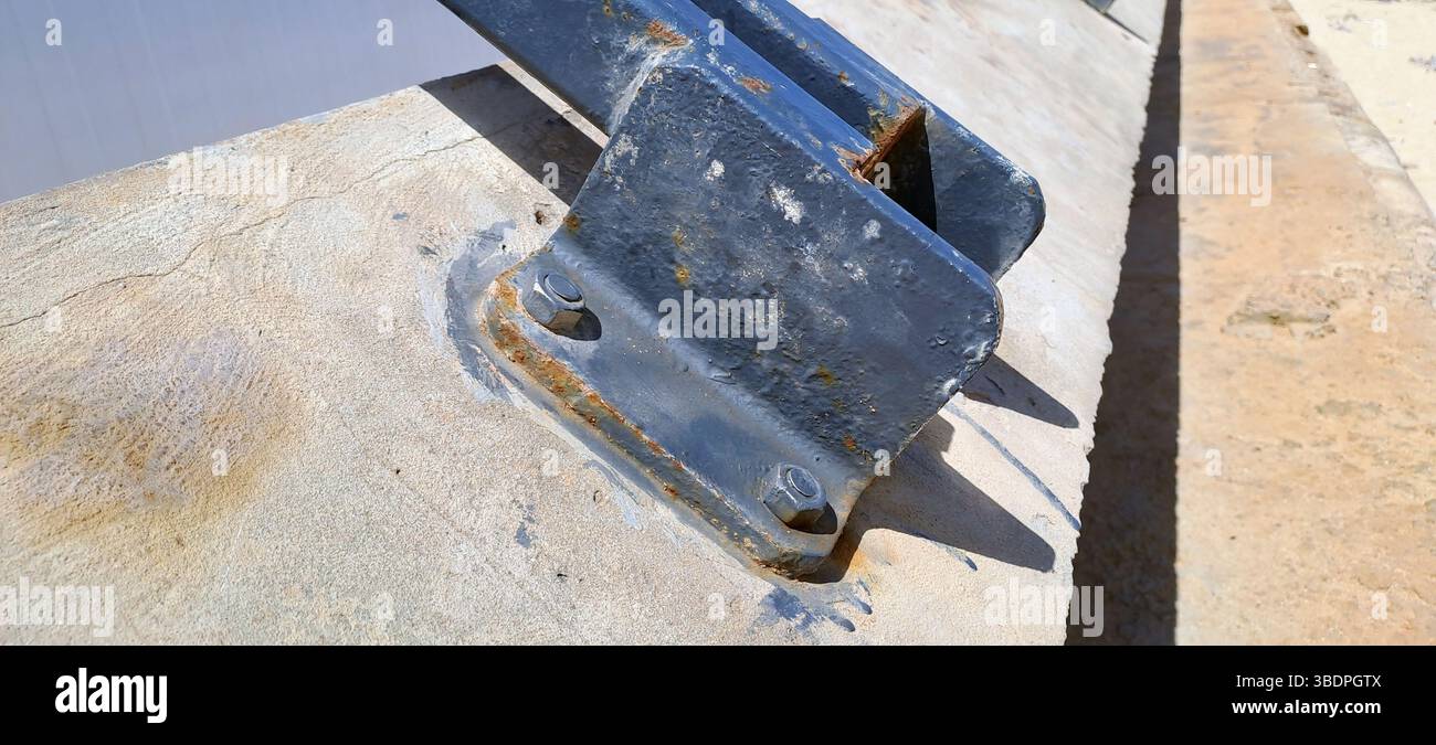 Close-up of rusty metal brackets and bolts attaching a railing to a ...