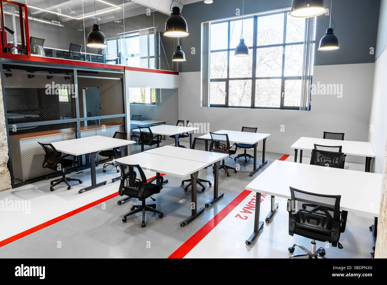 Modern workspace with multiple desks and bright natural light in a collaborative office ...