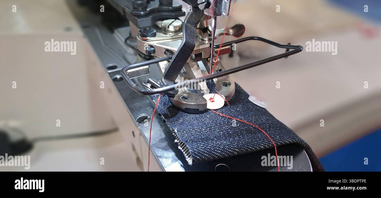 Close-up of sewing machine attaching button to denim, showcasing ...