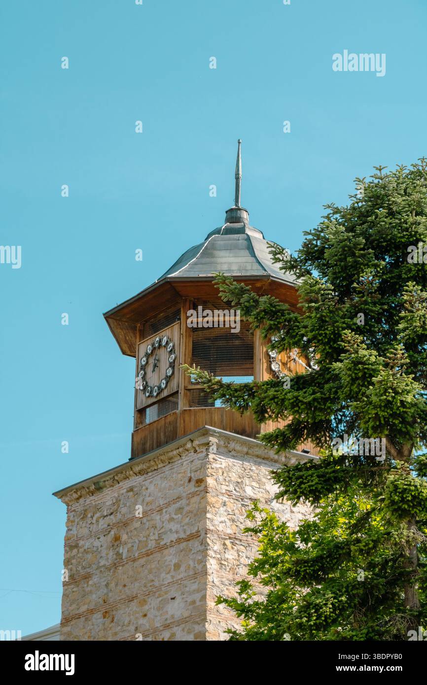 A beautifully crafted clock tower stands prominently in a tranquil town ...