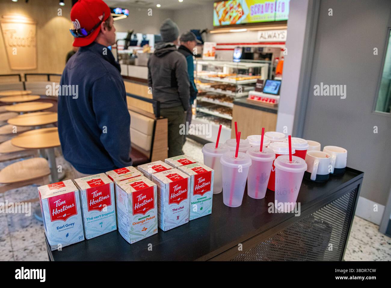 Consumers wait in line to buy coffee from Tim Hortons' coffee shop in ...