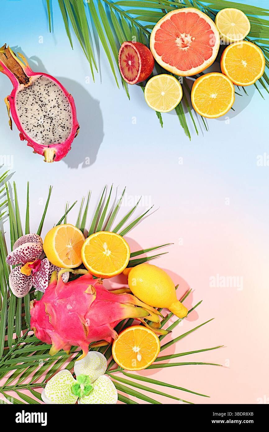 Dragon fruit, pitaya, oranges, lemons, orchid flowers on palm leaves ...