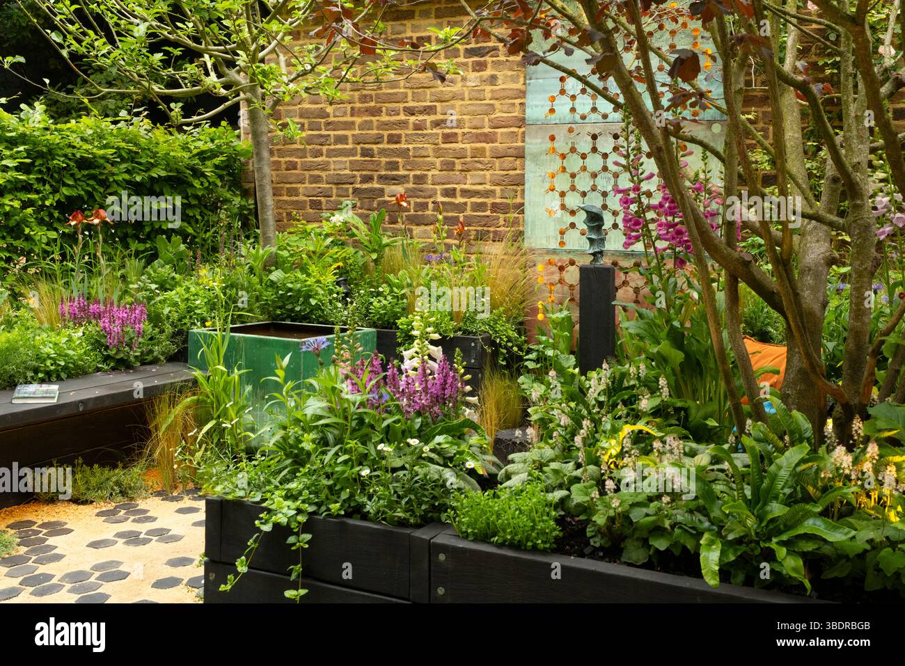 A patio garden with plant filled containers designed by Joshua Fenton ...
