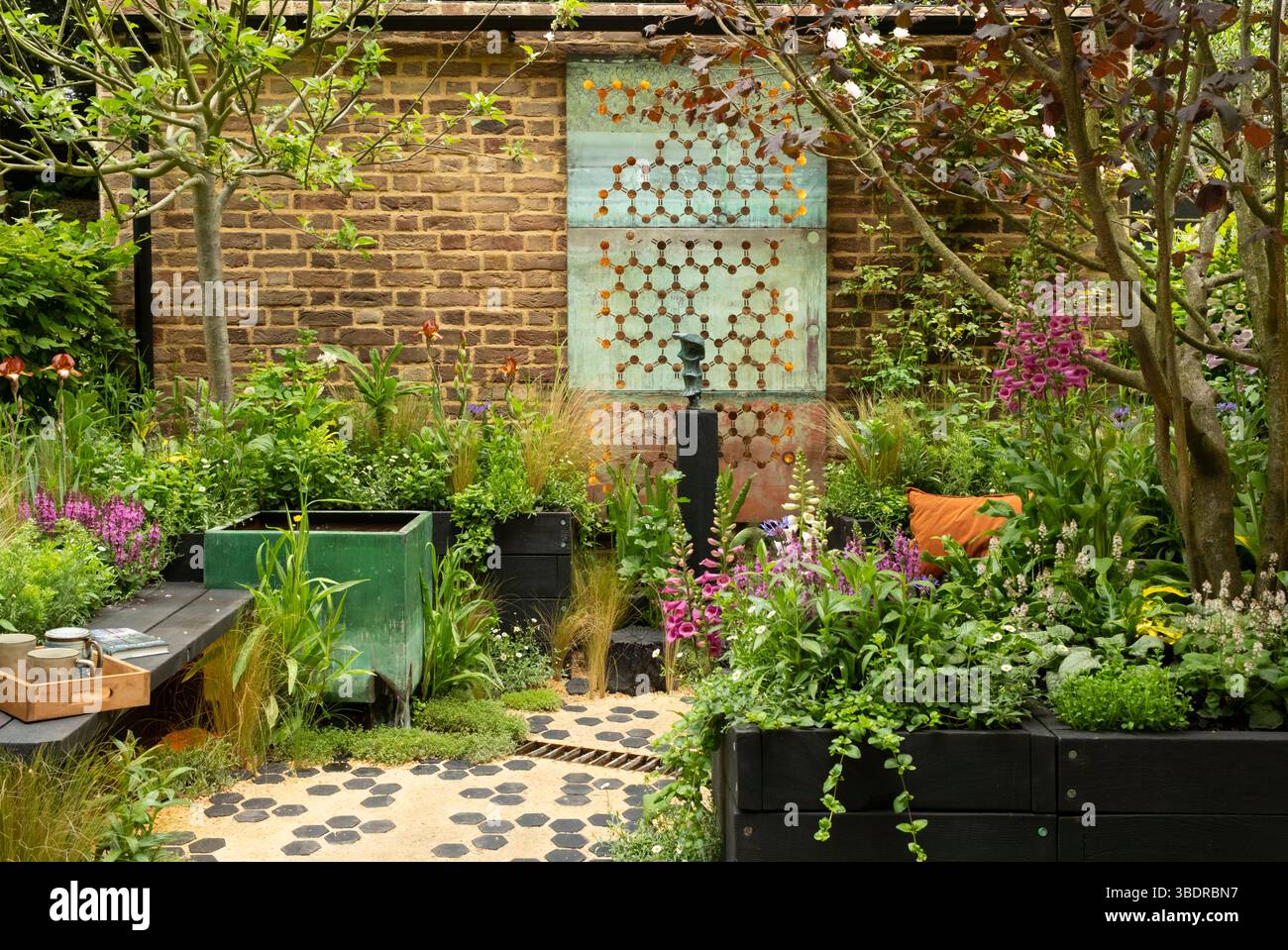 A patio garden with plant filled containers designed by Joshua Fenton ...