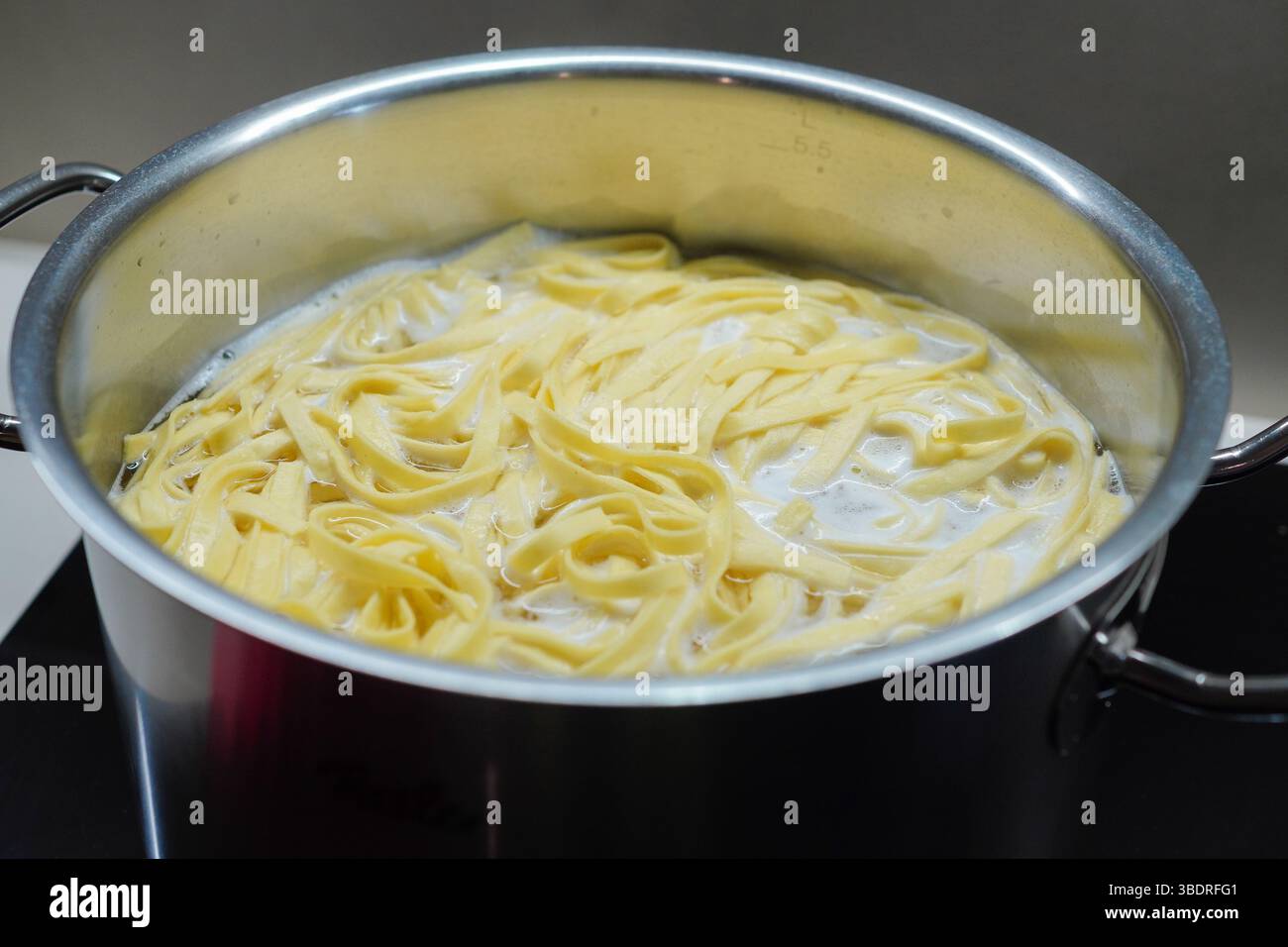 Cooking (boiling) pasta tagliatelle in a pot of boiling water Stock ...