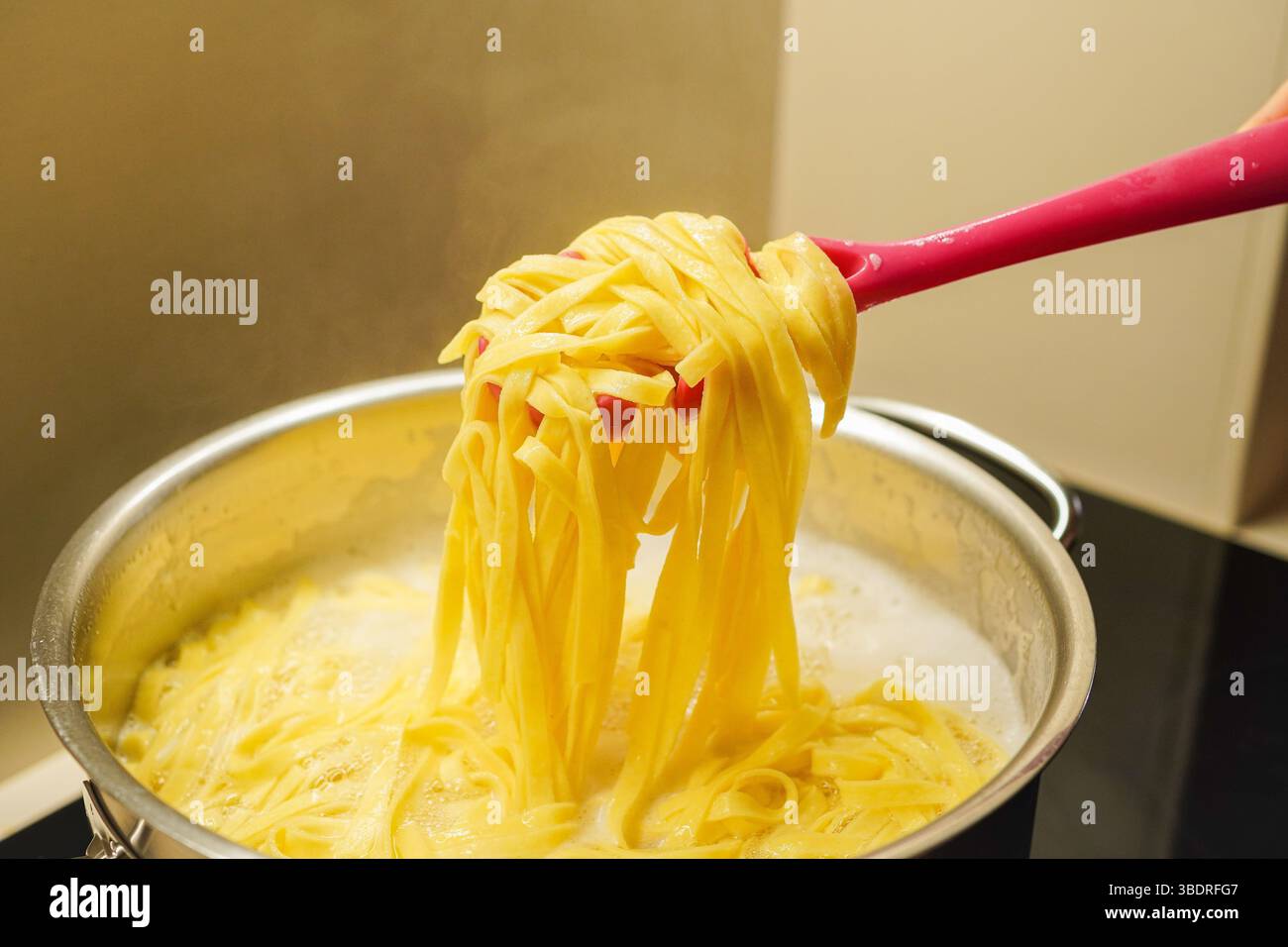 Cooking (boiling) pasta tagliatelle in a pot of boiling water Stock ...