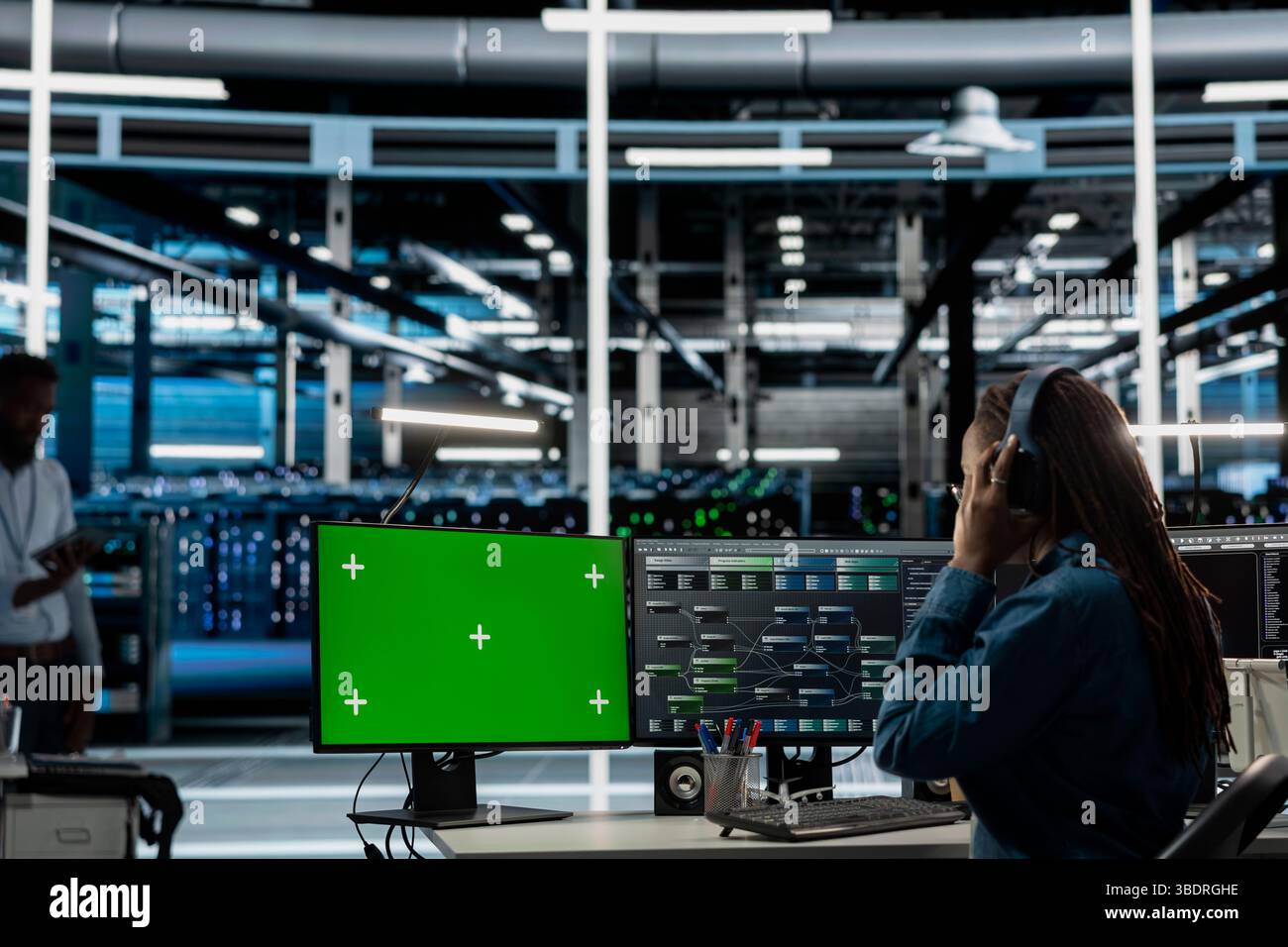Servers room employee wearing audio headset doing maintenance using mockup PC. Technician in ...
