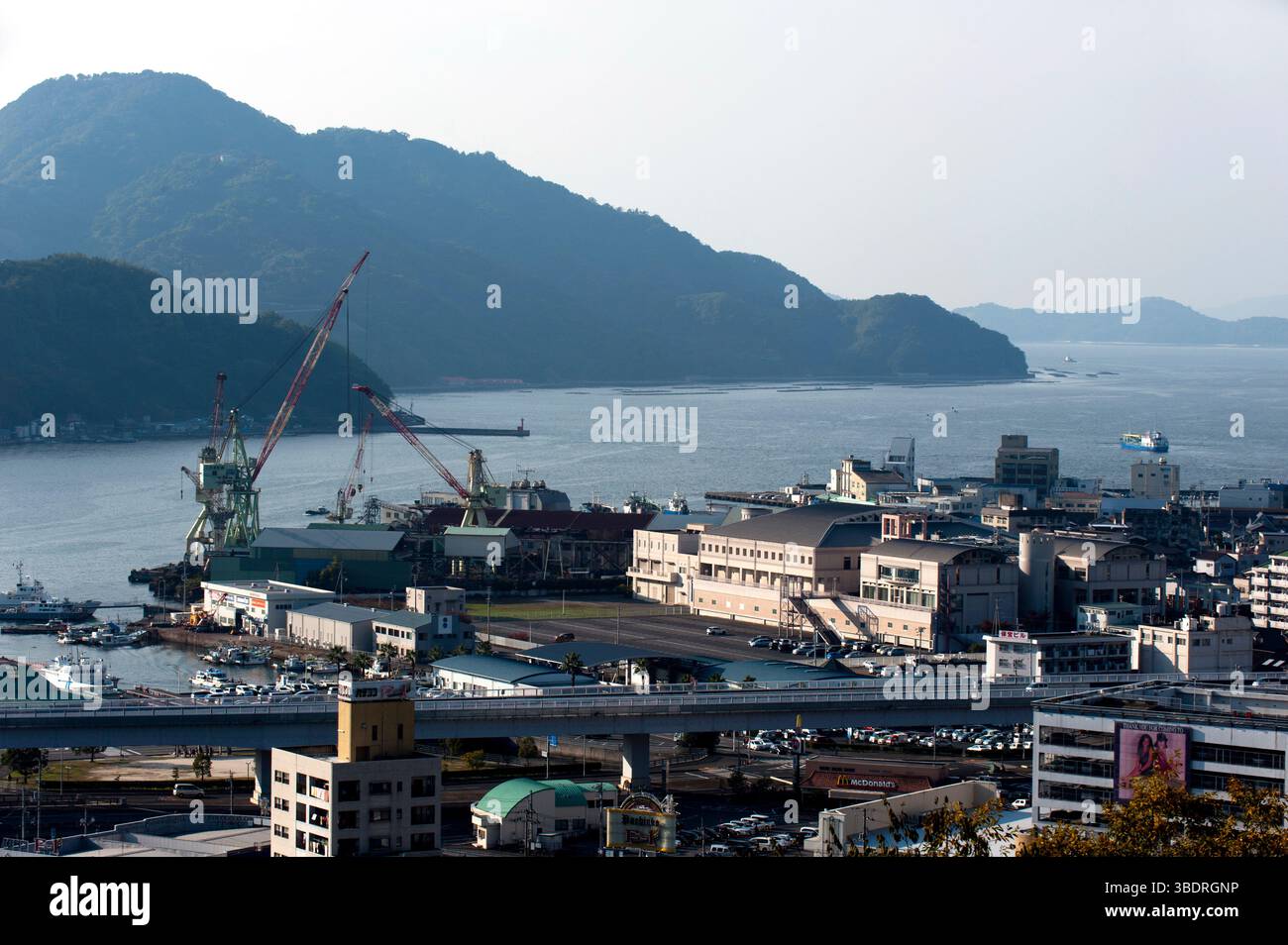 Bird's-eye aerial view from top of Uwajima Castle of Uwajima City and ocean harbor mountain ...
