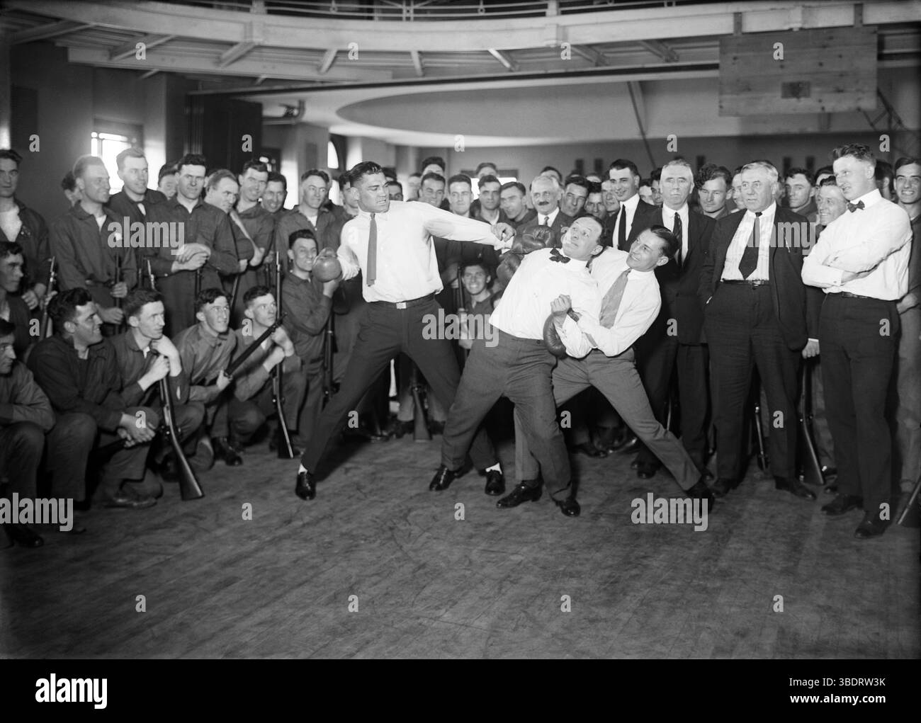 Boxer Jack Dempsey mock punching Harry Houdini (held back by Benny ...