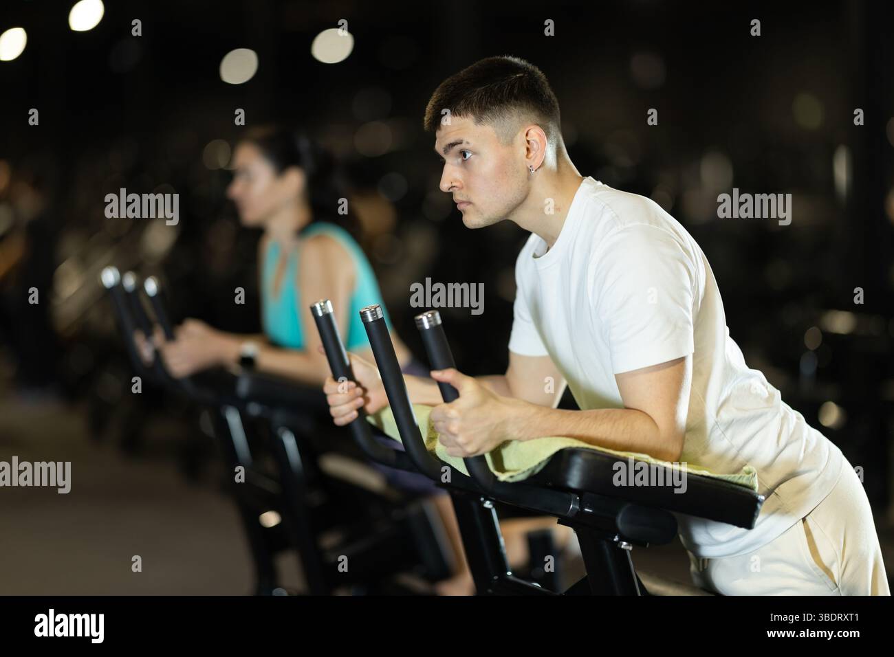In gym, guy uses gym apparatus to strengthen leg muscles Stock Photo ...