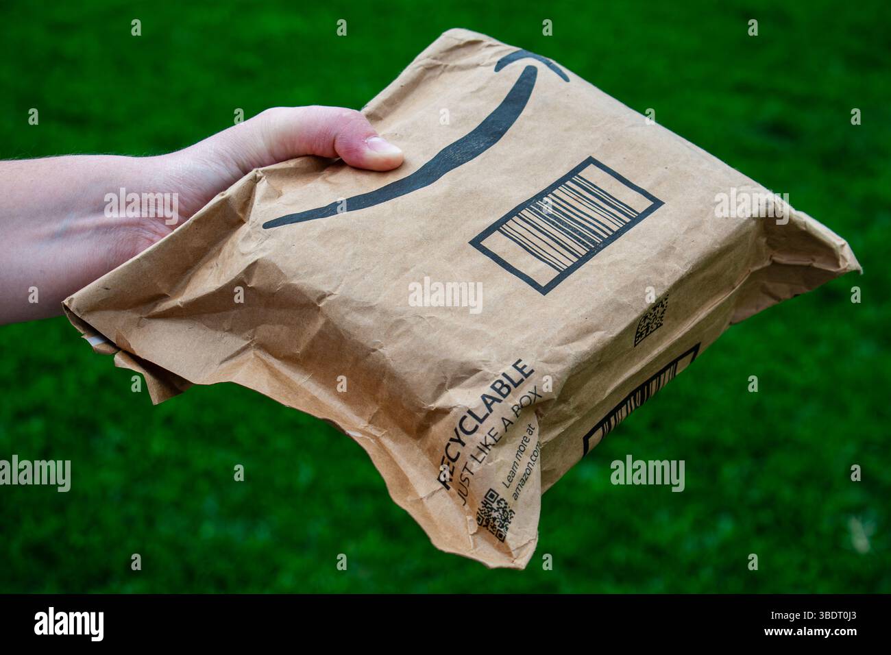 San Francisco, CA, US – May 24, 2025: A person outdoors holds an Amazon ...