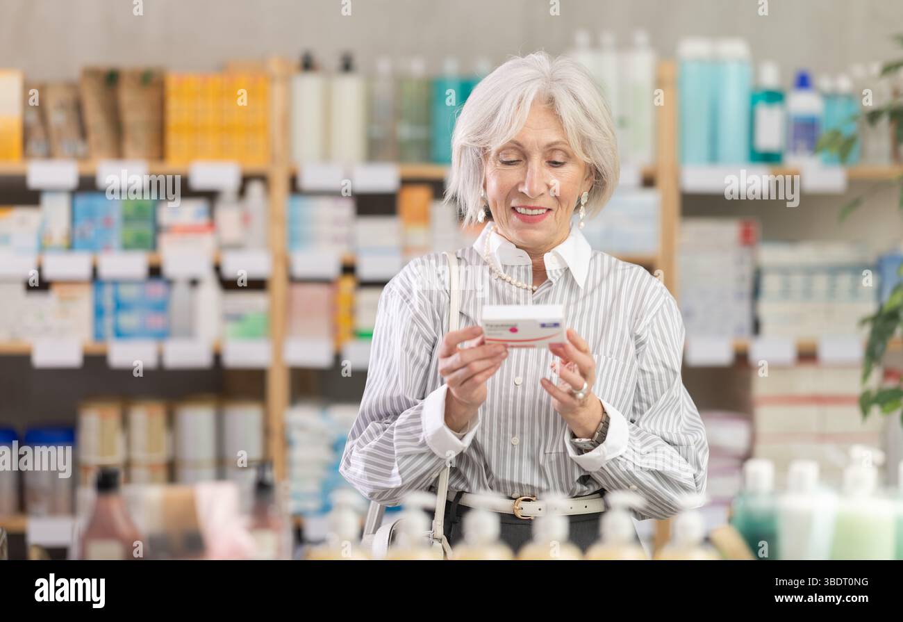 Elderly woman in summer clothes scans code on package of paracetamol ...