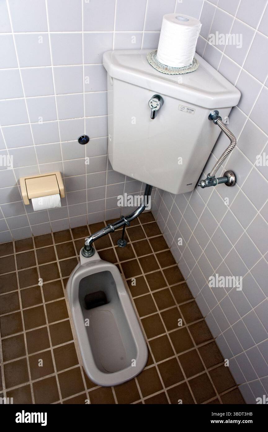 A traditional old-fashioned Japanese squat style toilet water closet ...