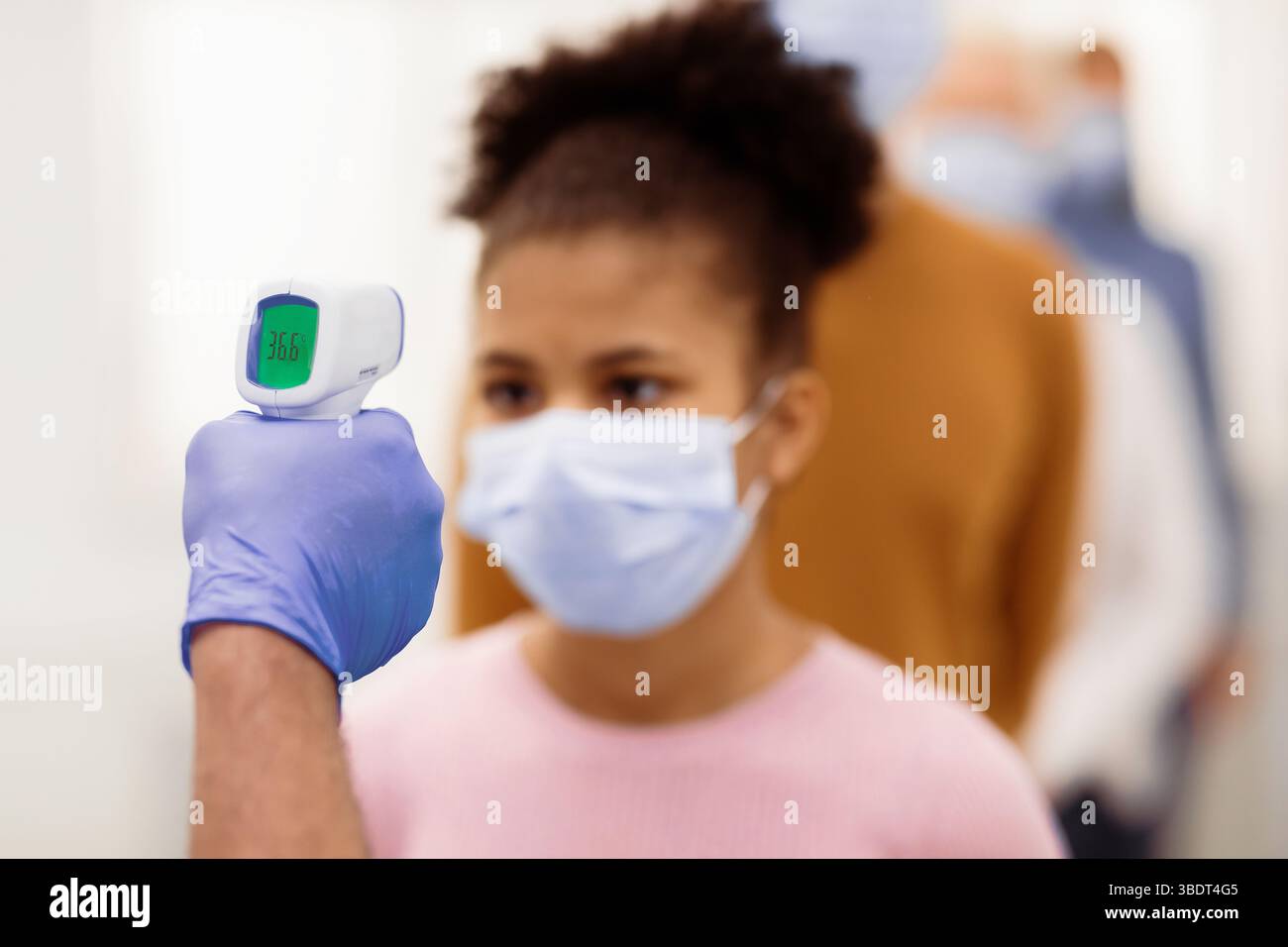 Medical Worker Doing Temperature Screening For People In Queue Indoors ...