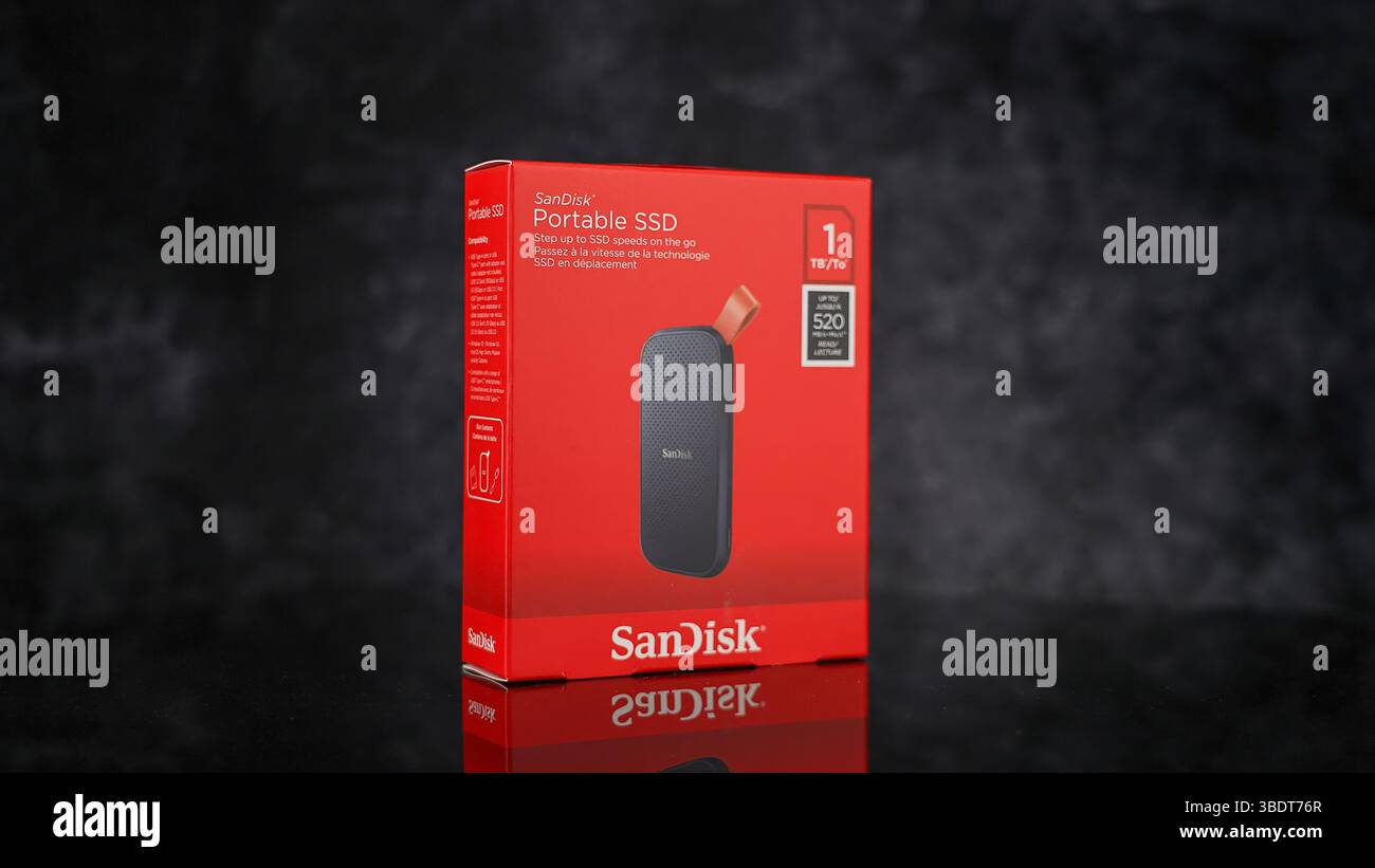 SanDisk portable SSD 1TB in red retail box packaging on a dark ...