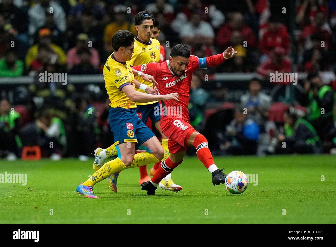 Toluca's Alexis Vega, right, is challenged by America's Israel Reyes ...