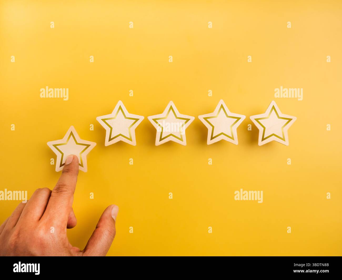 Five wooden stars ratings, pointing by customer hand, on yellow ...