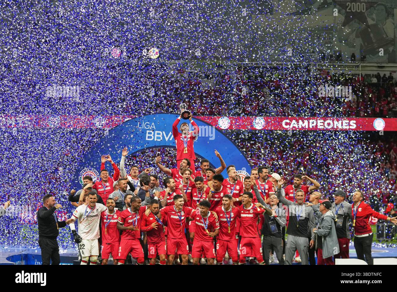 Toluca's Alexis Vega rises the winner's trophy after beating America on ...