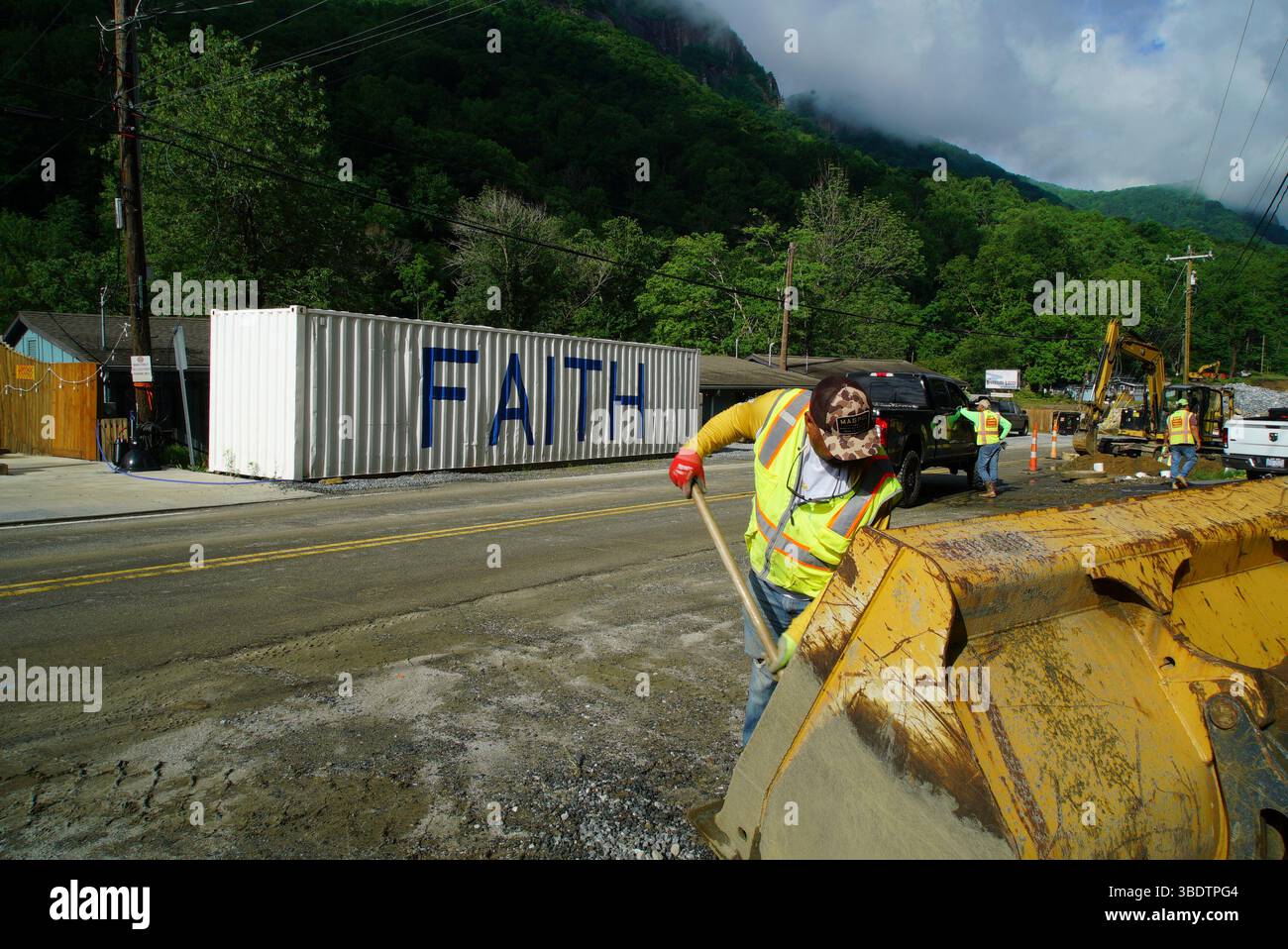 David Cruz mixes cement in the bucket of an end loader for a sewer ...