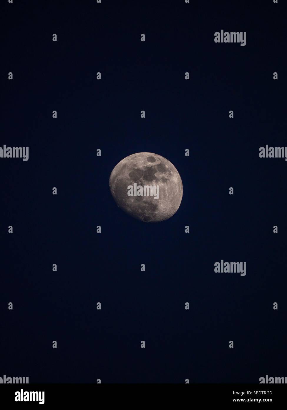 High-resolution photograph of the waxing gibbous moon in the night sky ...