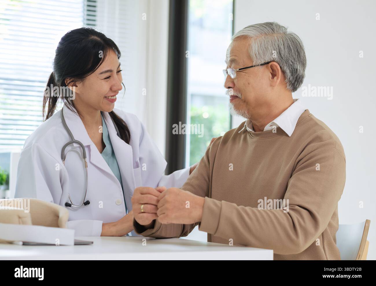 Doctor happily informs senior patient about full recovery during follow ...