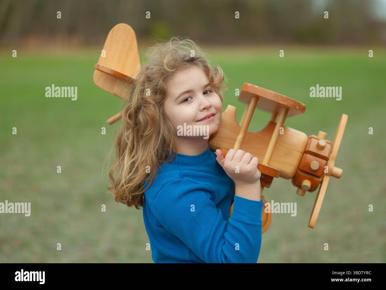 Kids dream. Happy kid play with wooden plane outdoor. Child playing ...