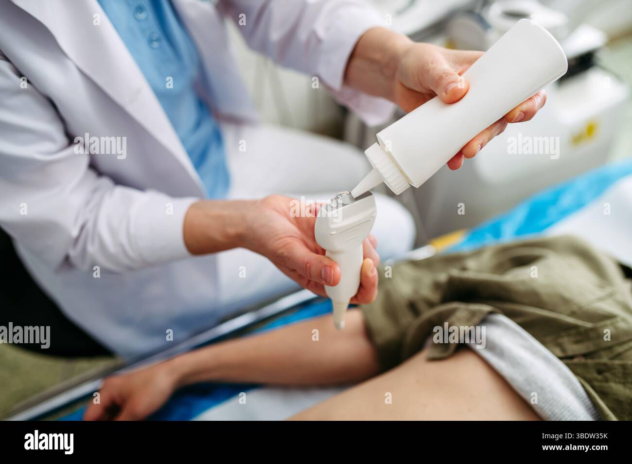Radiologist applying gel to ultrasound probe before abdominal scan ...
