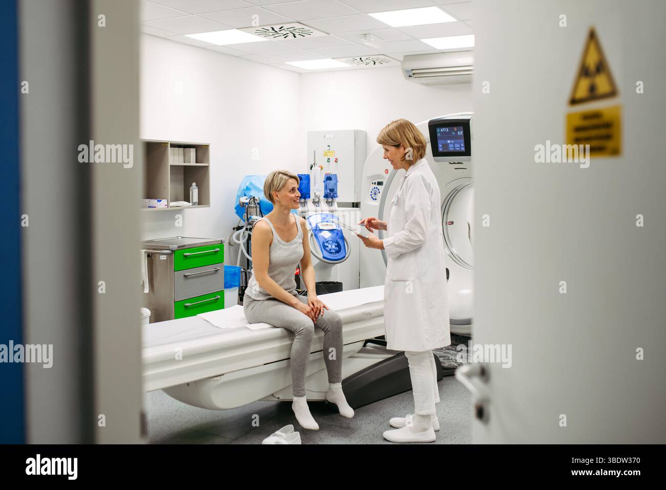 Doctor sharing positive CT scan results with smiling patient in imaging ...