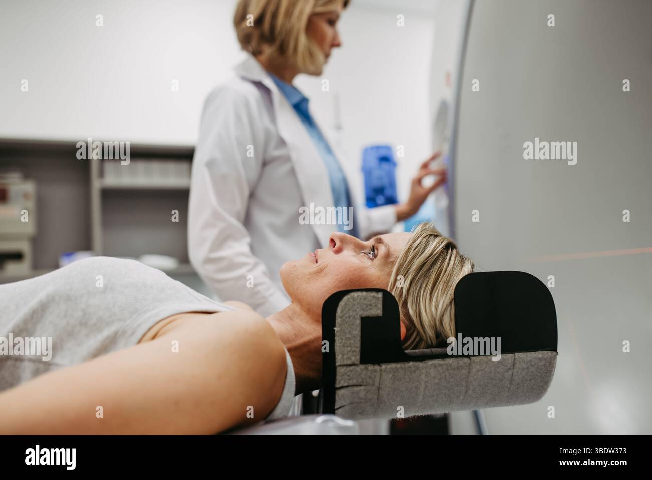 Patient positioned for head scan with laser alignment in CT scanner ...