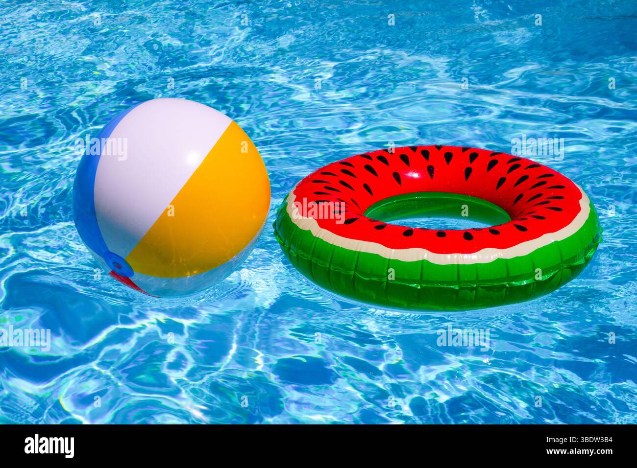 Summer day by the pool. Floating beach ball on pool water. Summer ...