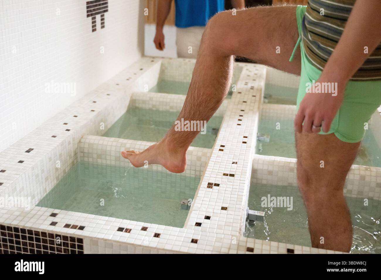 Man Stepping in Spa Water Walkway.Close up of a mans legs as he steps ...