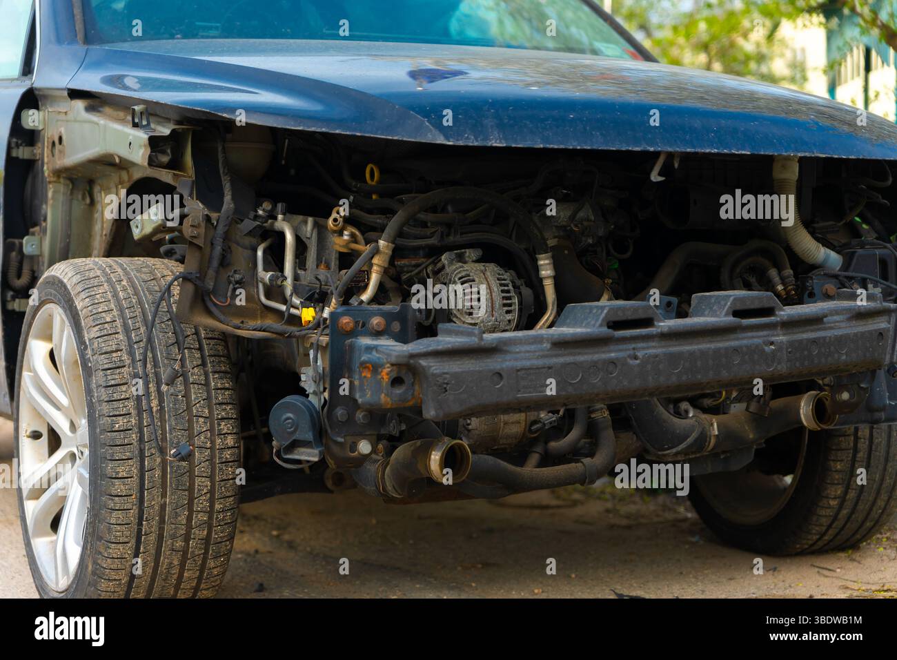 Front view of a damaged vehicle with missing bumper and exposed engine ...