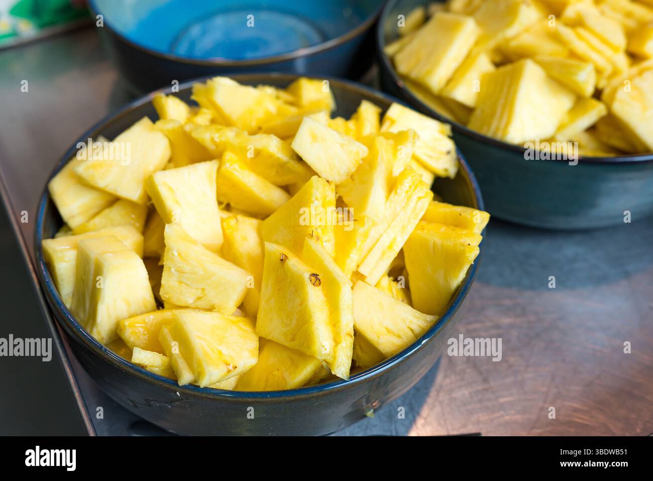 bowls of fresh cut pineapple chunks, ready to eat Stock Photo - Alamy