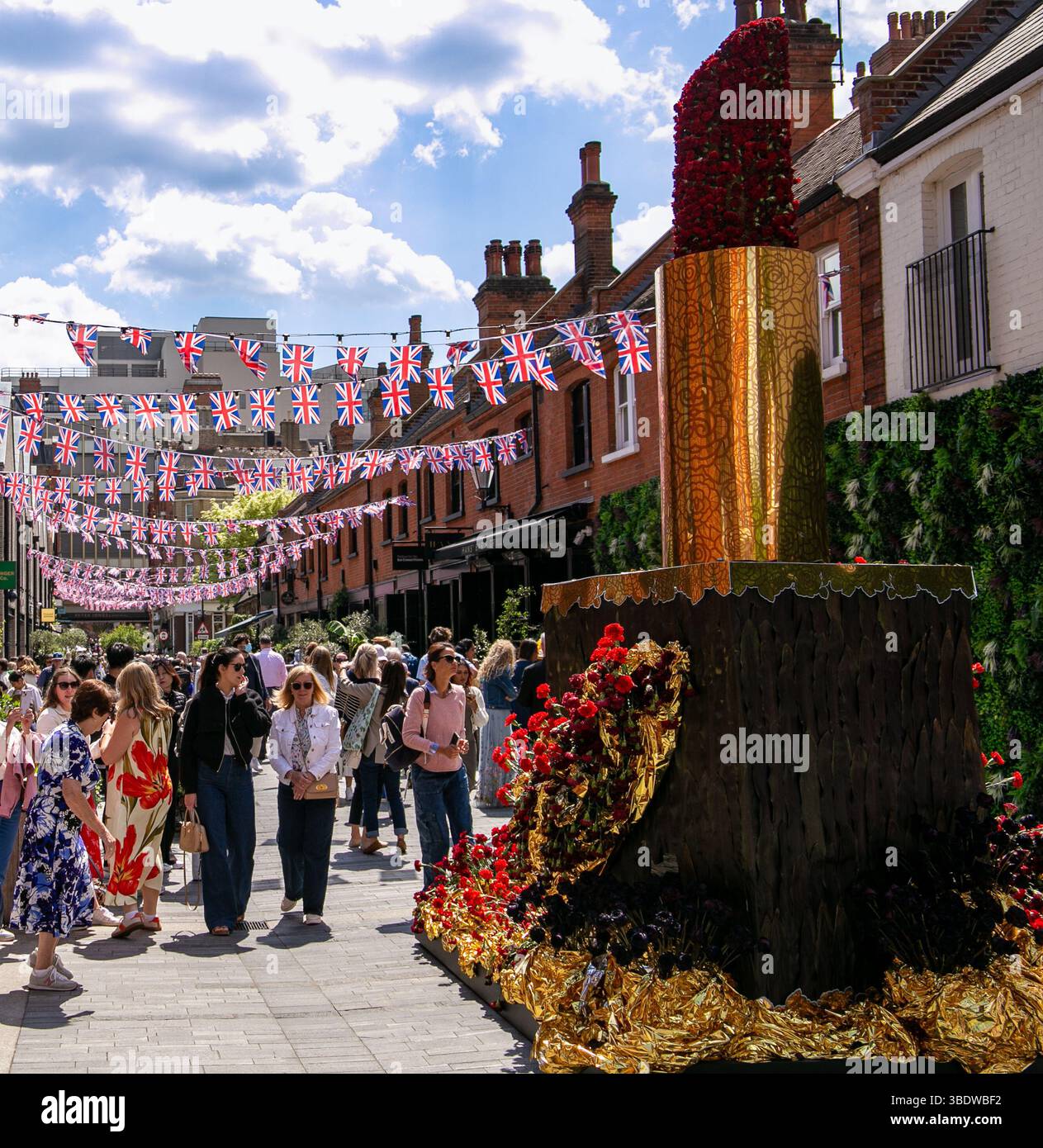 People gather in a London street decorated with Union Jack flags and a ...