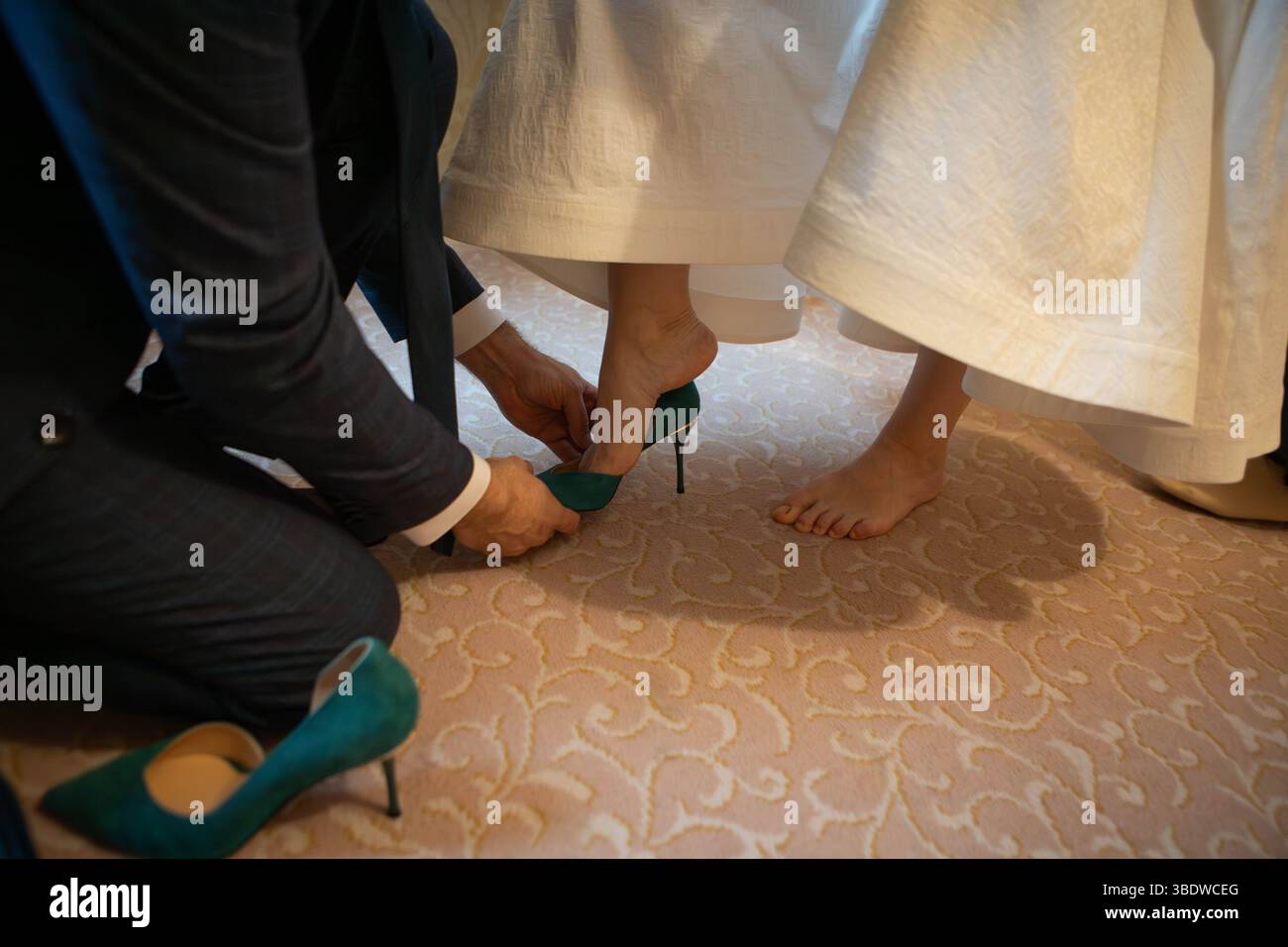 The bride's groom puts shoes on his feet on his wedding day - close-up ...