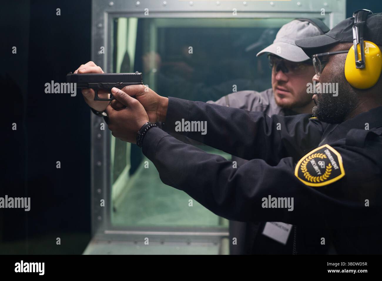 Instructor teaching safety measures at indoor shooting range, ensuring ...
