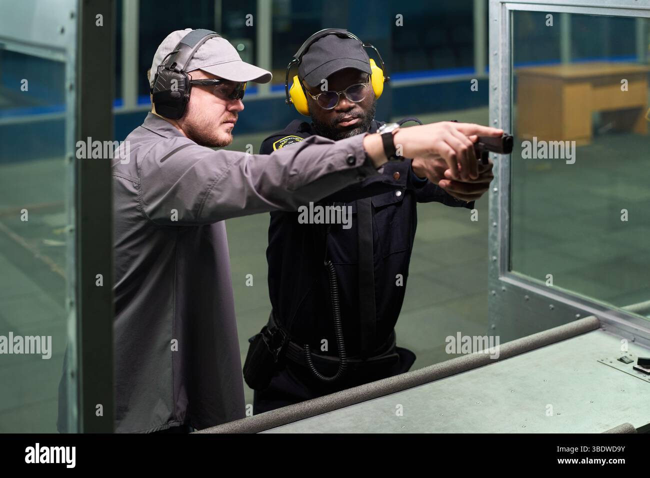 Gun instructor giving shooting lessons at indoor gun range, displaying ...