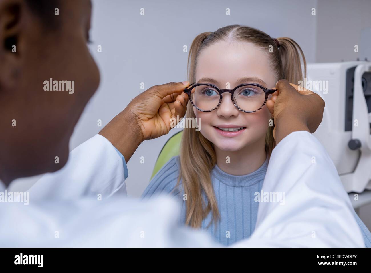 Cute caucasian girl trying on new glasses in optometrist office Stock ...