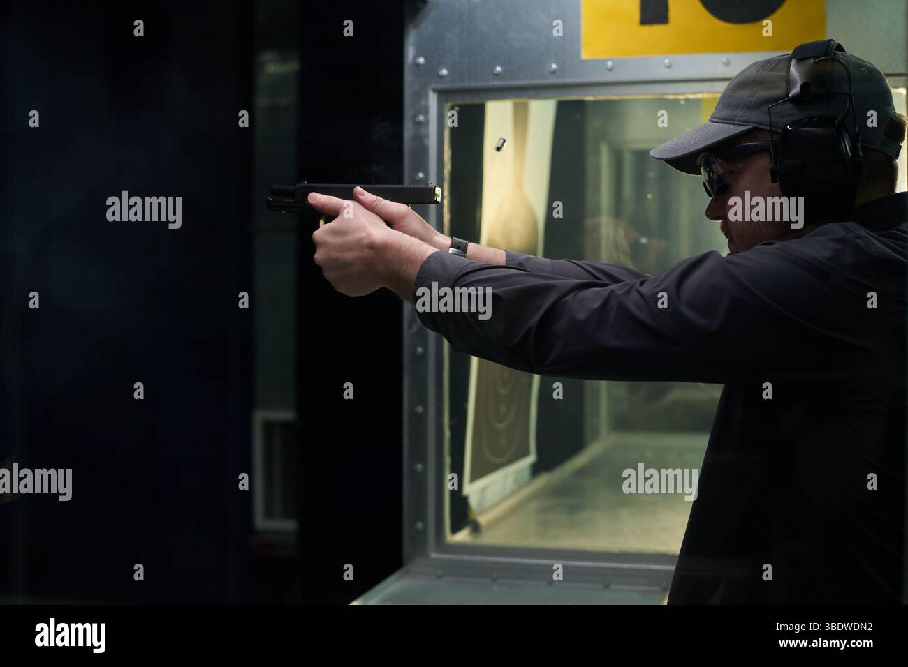 Individual practicing shooting skills at indoor gun range while aiming ...